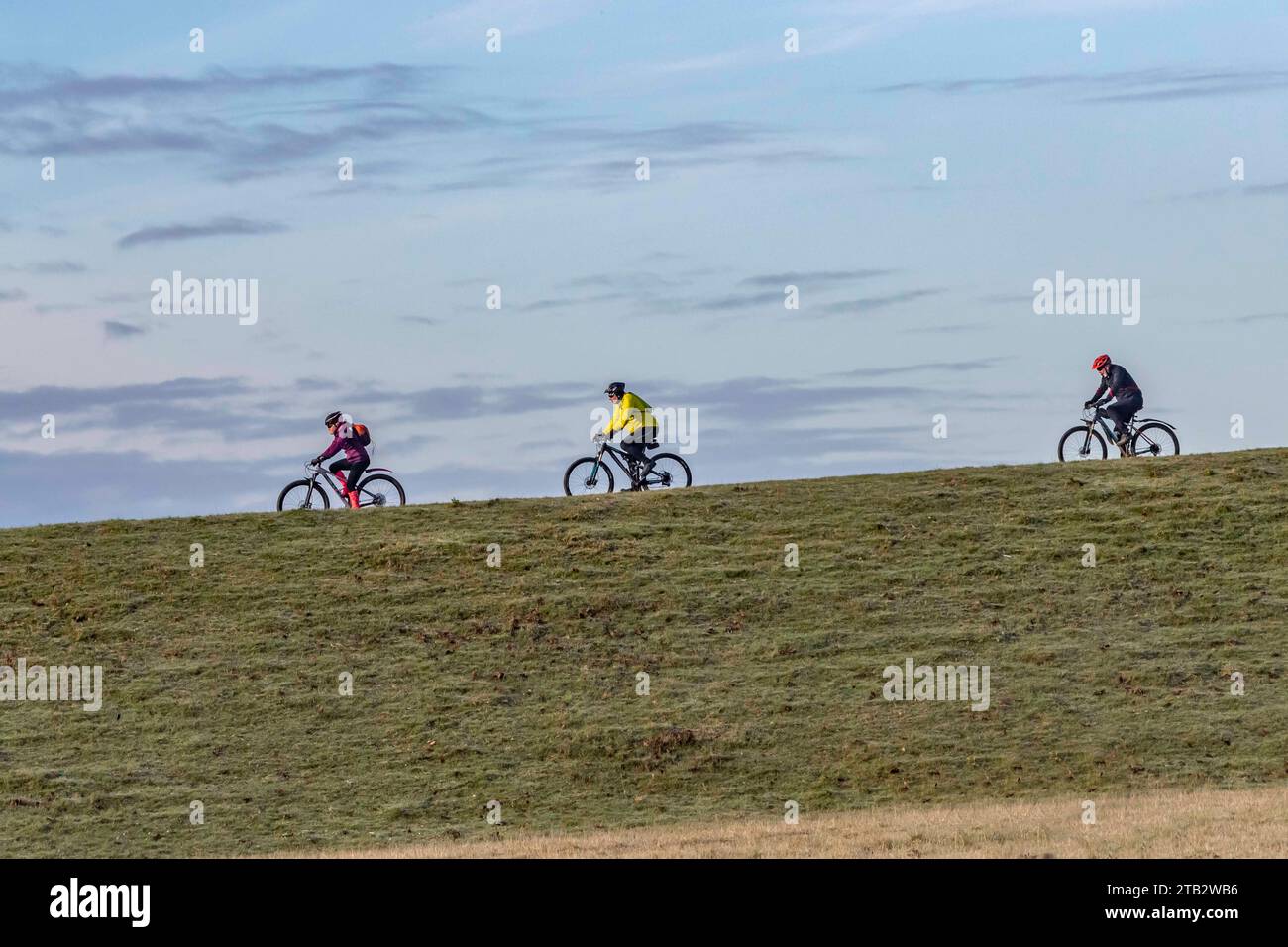 3 cyclists in the distance riding aound the rim of the washland ...