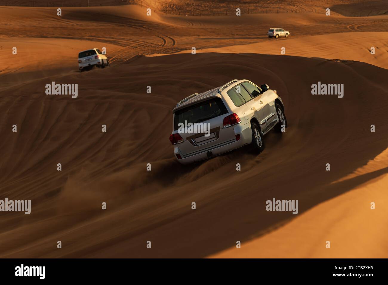 White car driving in Rub al Khali Desert at the Empty Quarter, in Abu ...