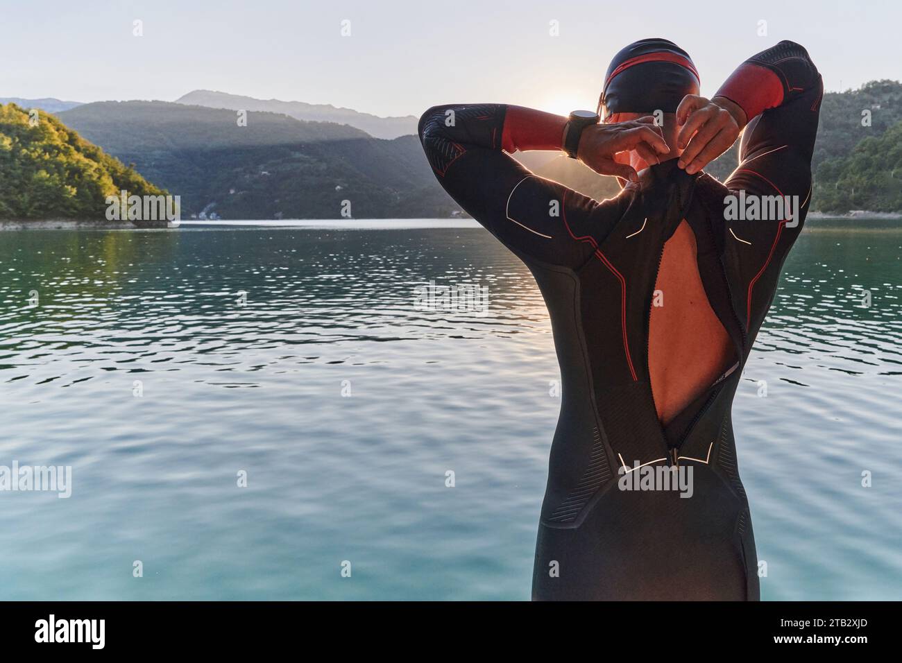 Authentic triathlon athlete getting ready for swimming training on lake ...