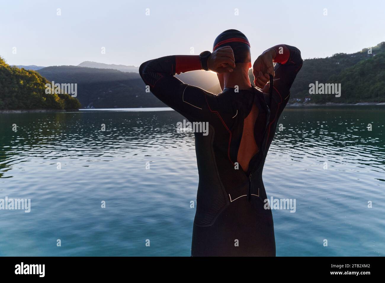 Authentic triathlon athlete getting ready for swimming training on lake ...