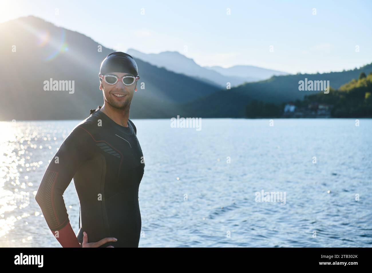 Authentic triathlon athlete getting ready for swimming training on lake ...