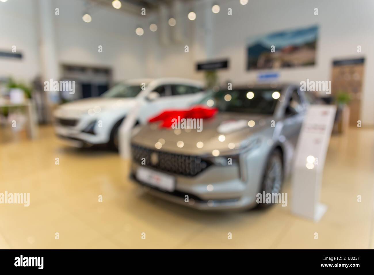 Blurred new car parked in modern showroom waiting for sales. Abstract ...