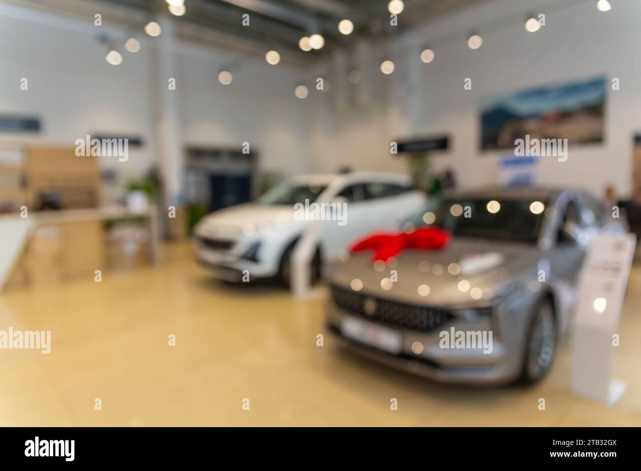 Blurred new car parked in modern showroom waiting for sales. Abstract ...