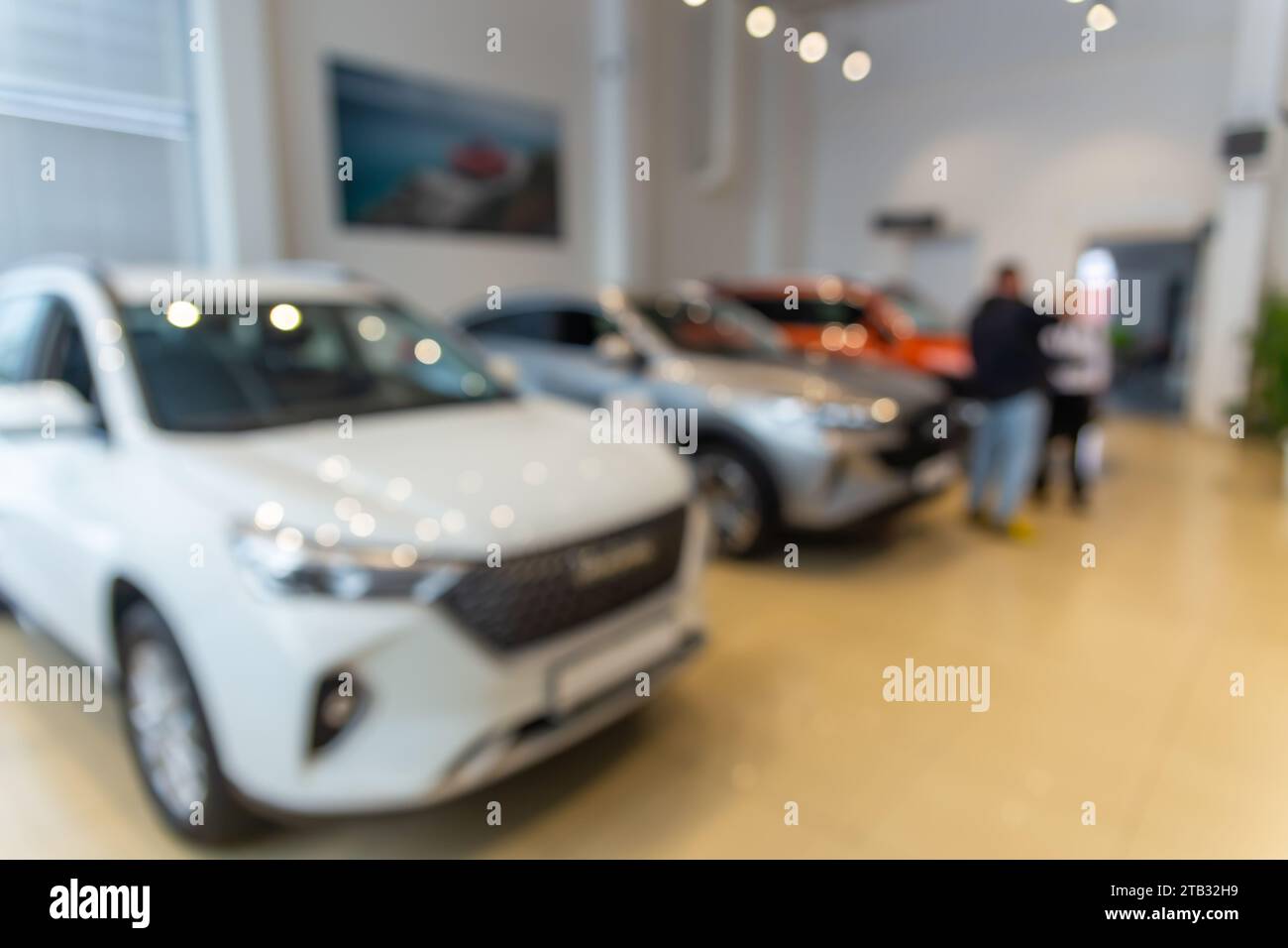 Blurred new car parked in modern showroom waiting for sales. Abstract ...