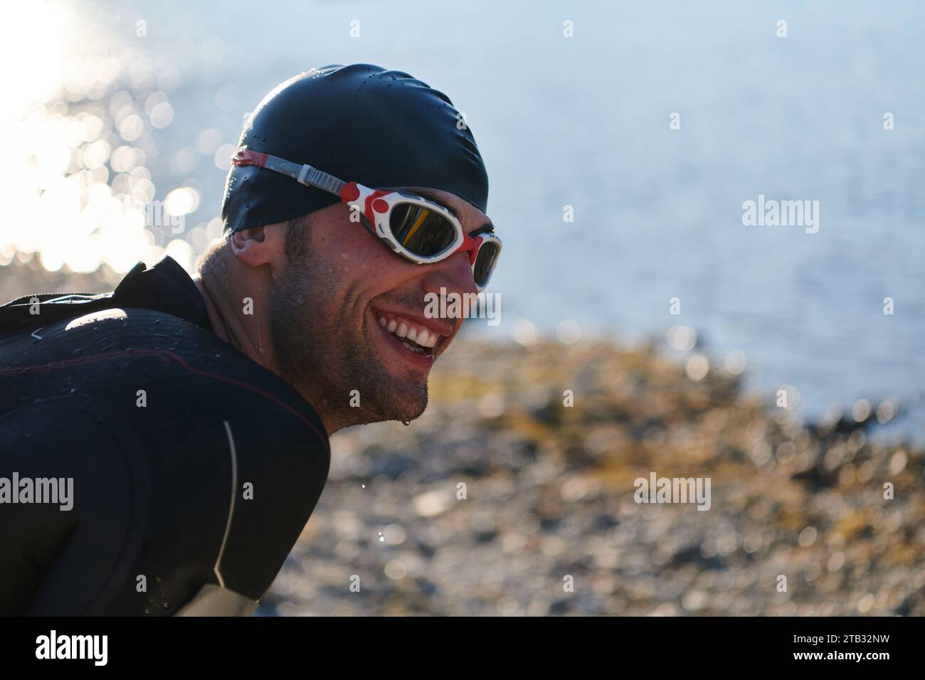 Authentic triathlon athlete getting ready for swimming training on lake ...