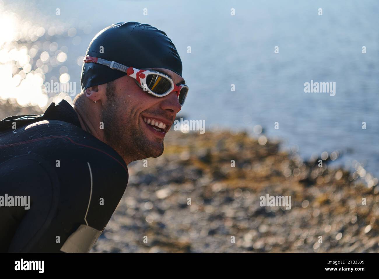 Authentic triathlon athlete getting ready for swimming training on lake ...