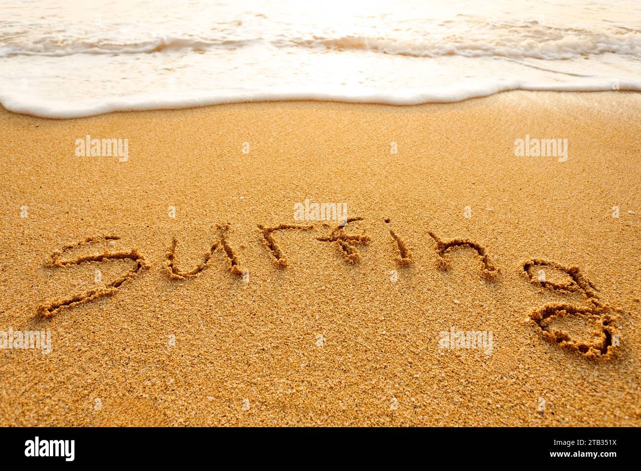 The word surfing written in the sand on the beach with the wave Stock ...