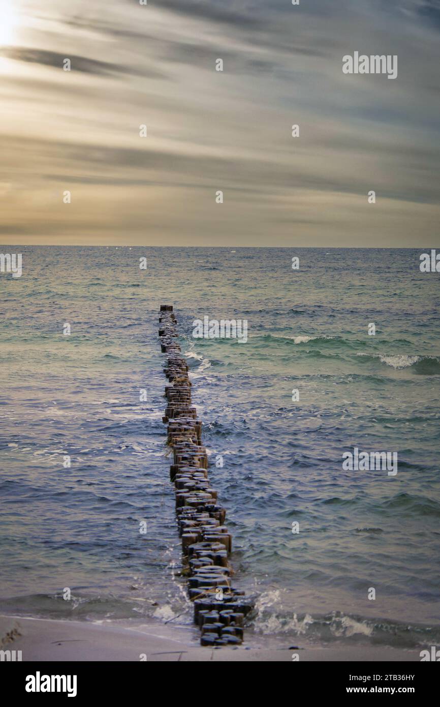 Groynes jut out into the Baltic Sea. Sunset on the horizon. Wooden logs ...