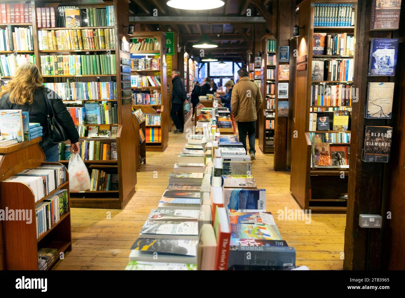 People looking at browsing books shelves in book shop town of Hay-on ...