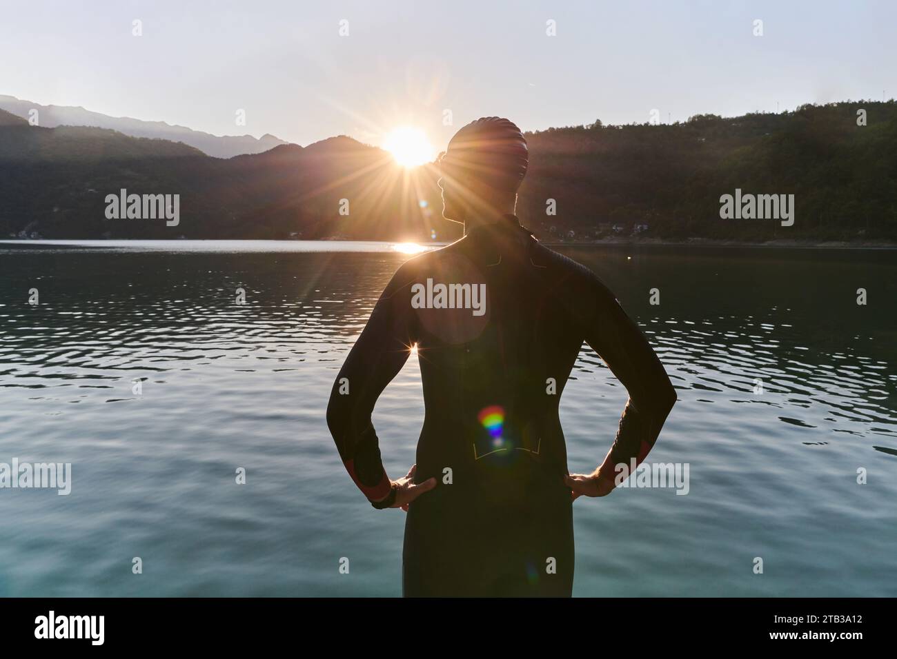 Authentic triathlon athlete getting ready for swimming training on lake ...