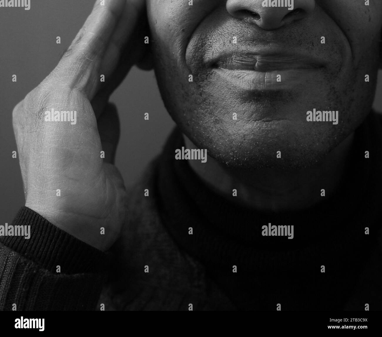 suffering from deafness and hearing loss on grey black background with ...