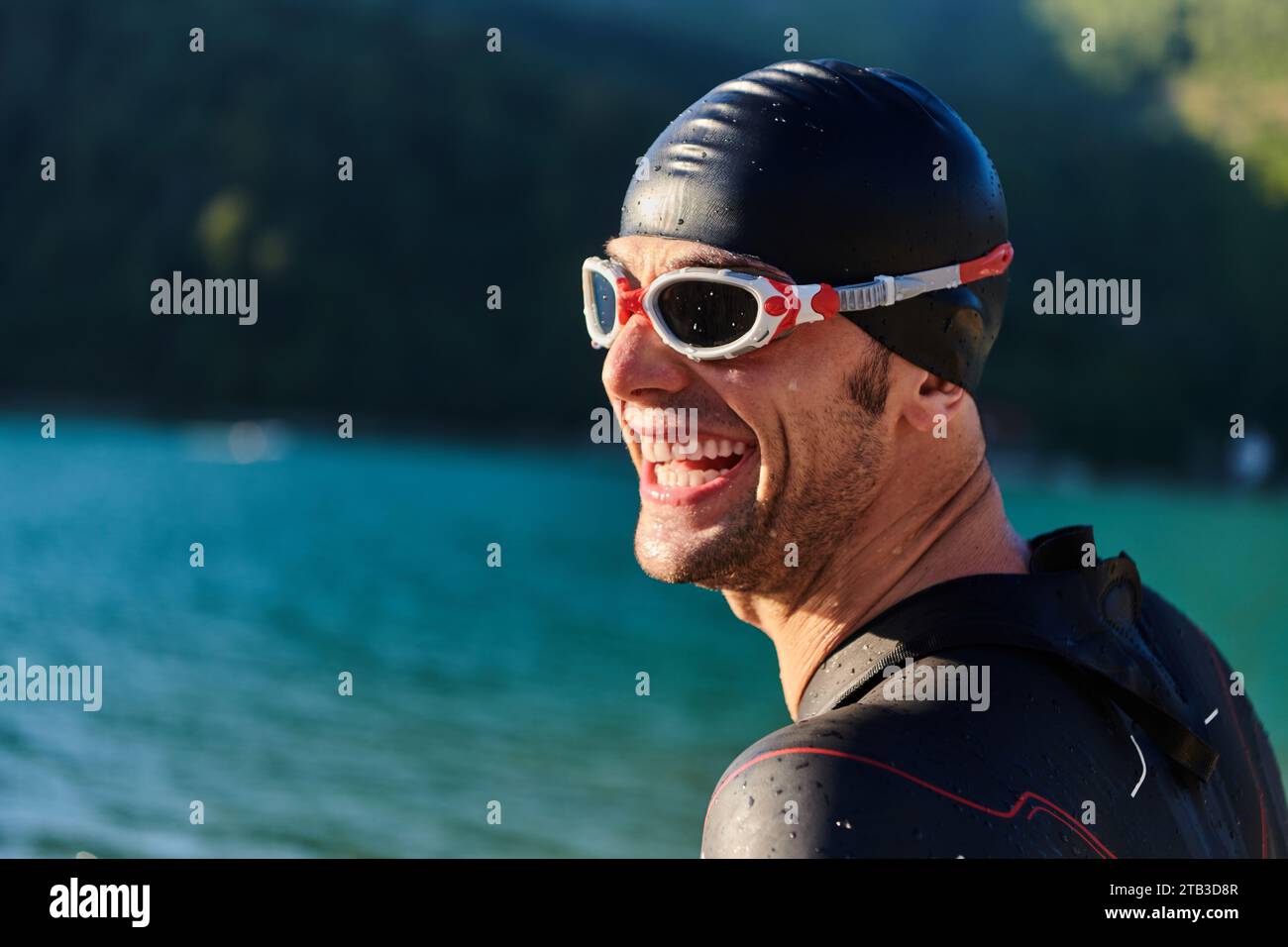 Authentic triathlon athlete getting ready for swimming training on lake ...