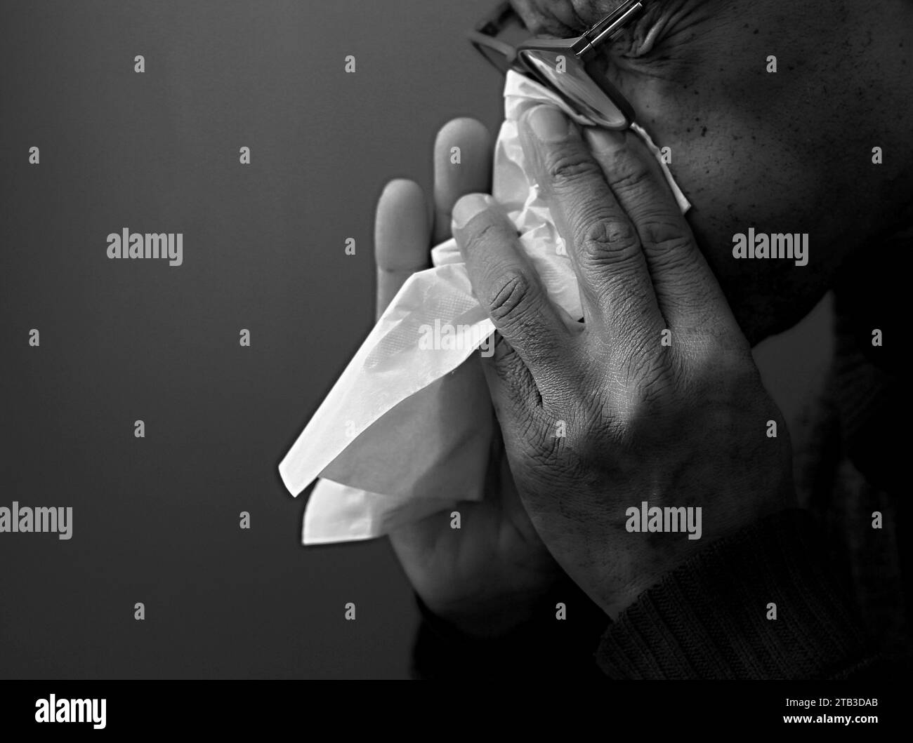 cold and flu blowing nose after catching flu on grey black background ...