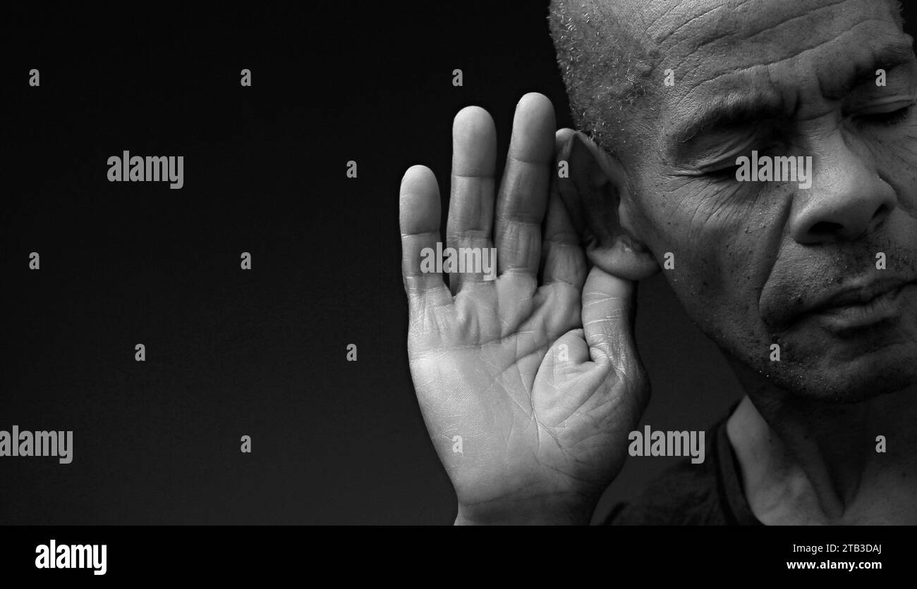 suffering from deafness and hearing loss on grey black background with ...