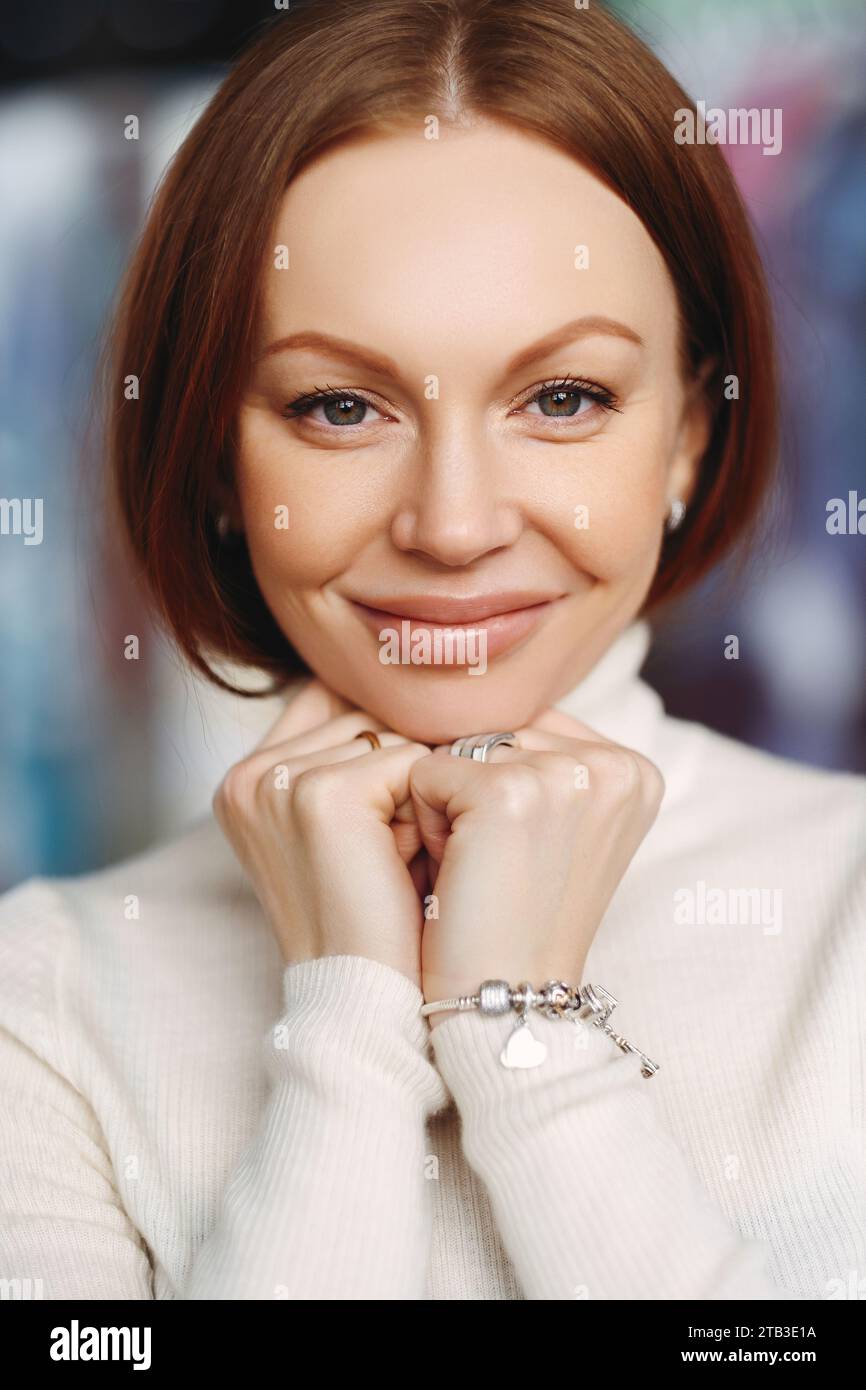 Elegant woman with charming smile in a cozy white sweater Stock Photo ...