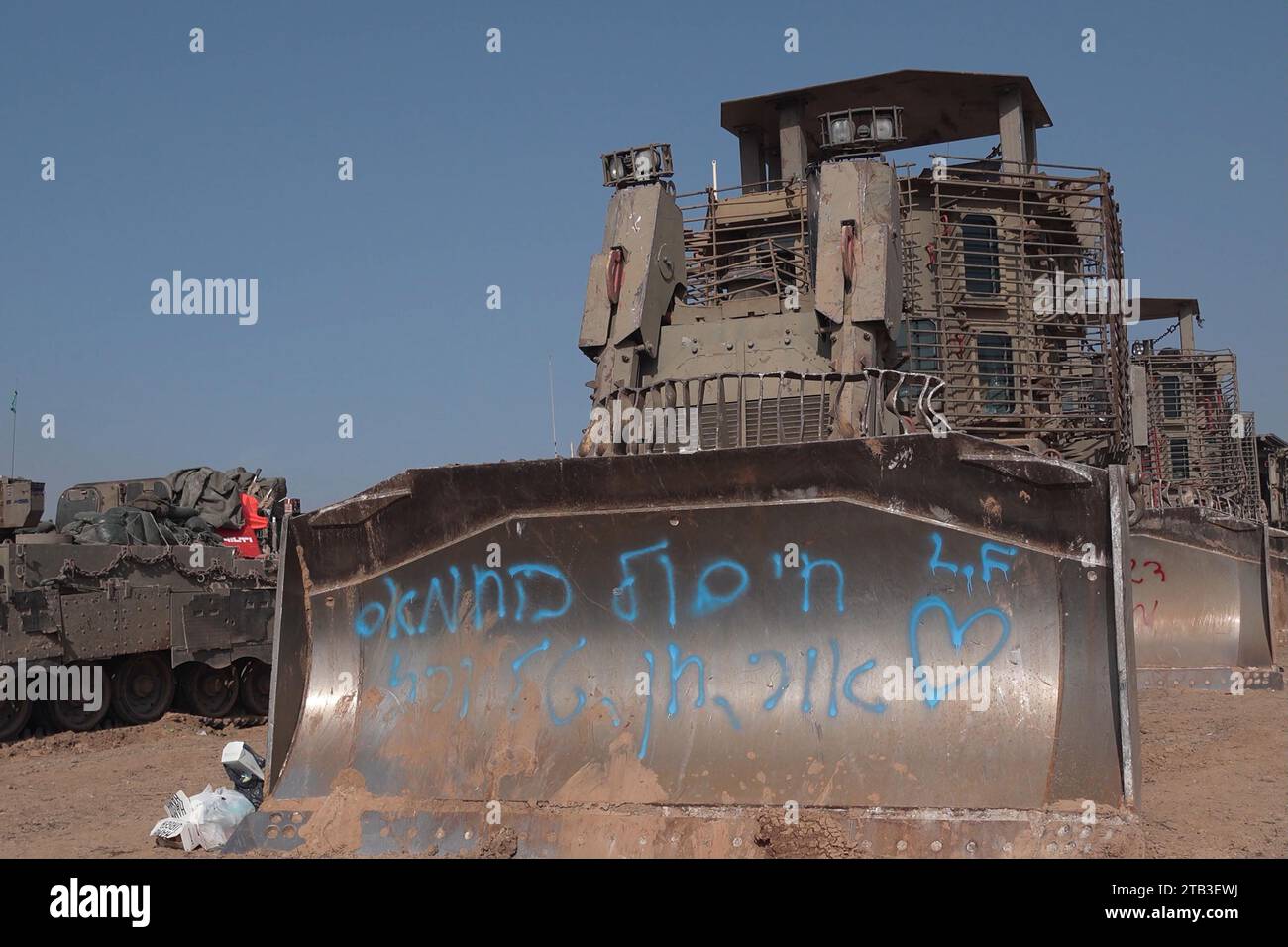 An Israeli D9 armored military bulldozer with a graffiti in blue that ...