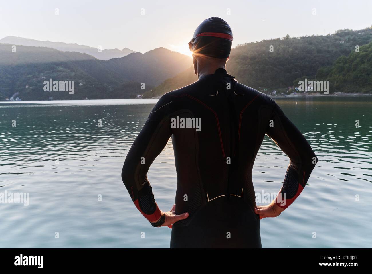 Authentic triathlon athlete getting ready for swimming training on lake ...