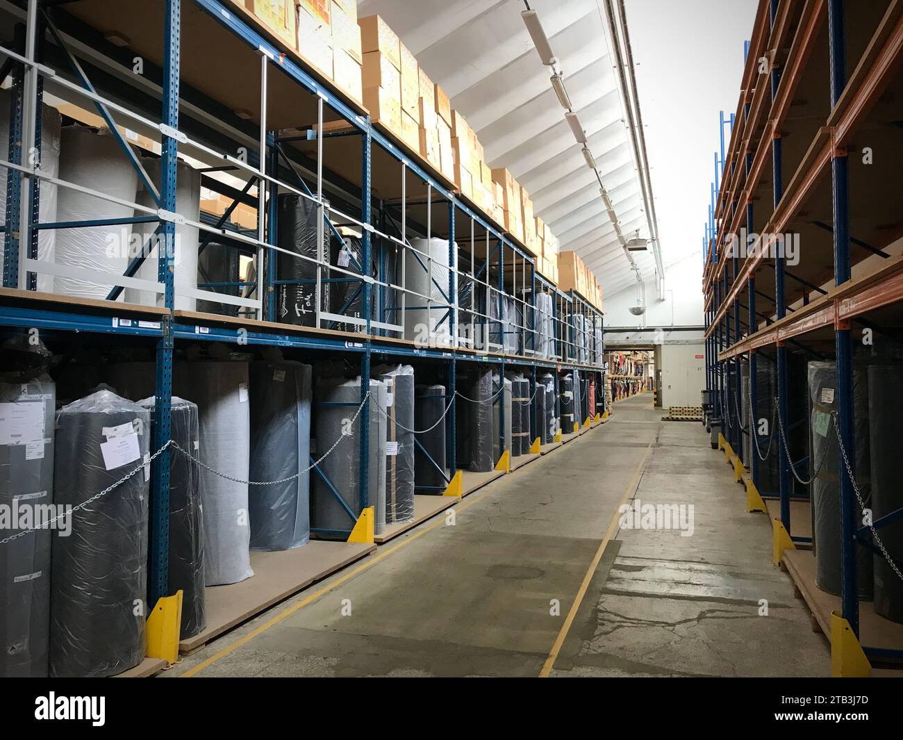 A warehouse with rolls of material standing on shelves Stock Photo - Alamy