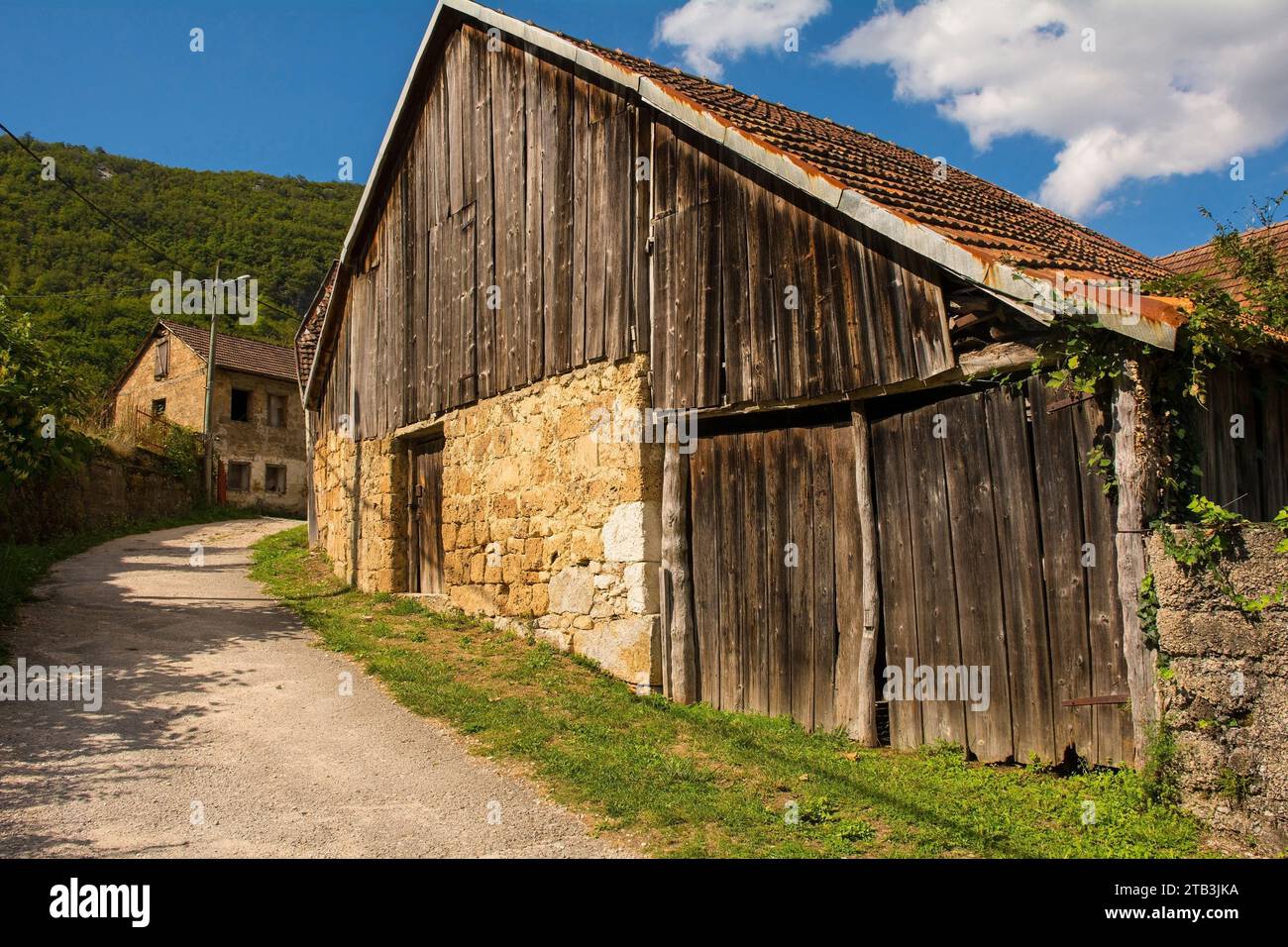 A quiet residential road with agricultural buildings in Martin Brod ...