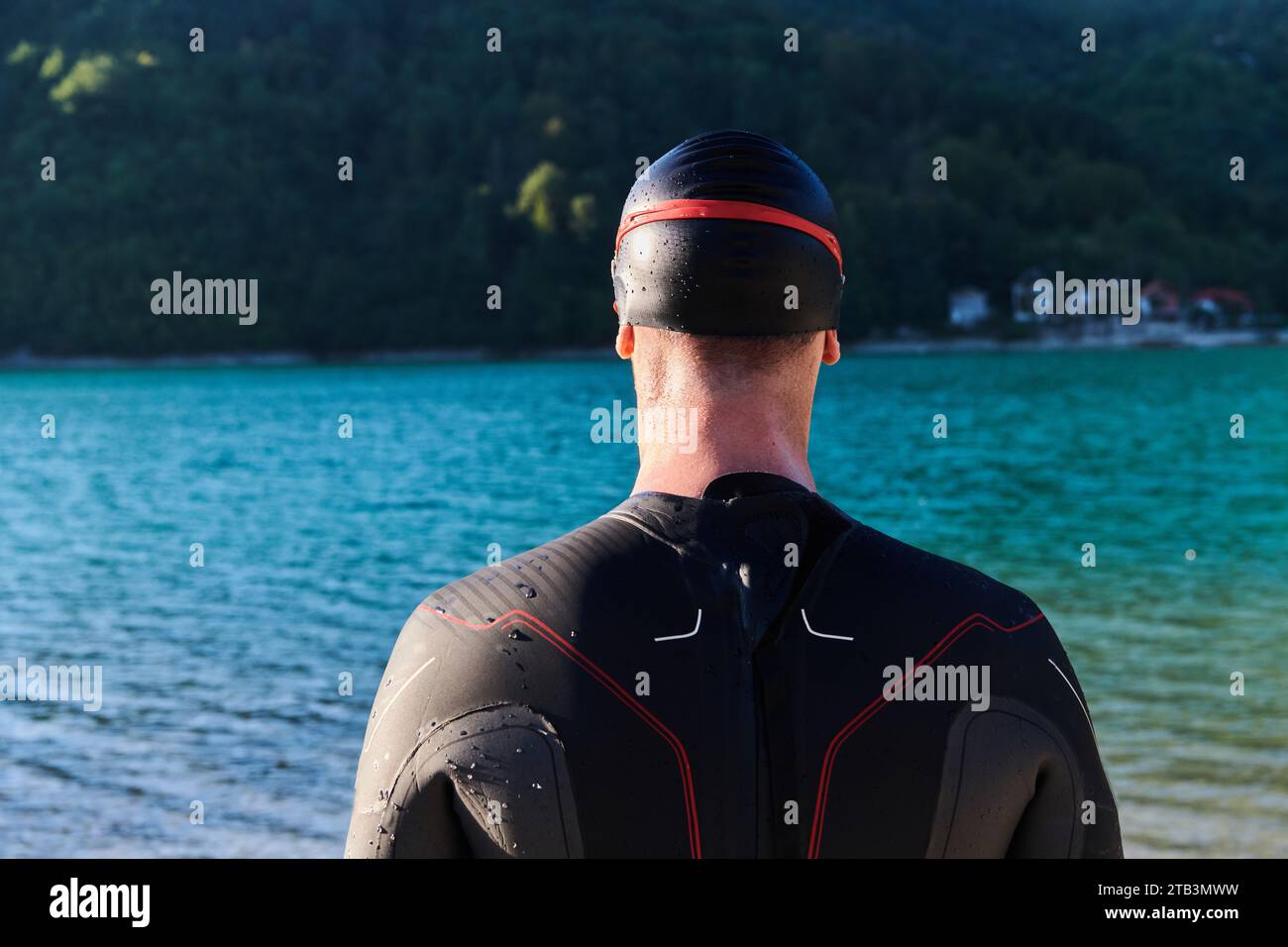 Authentic triathlon athlete getting ready for swimming training on lake ...