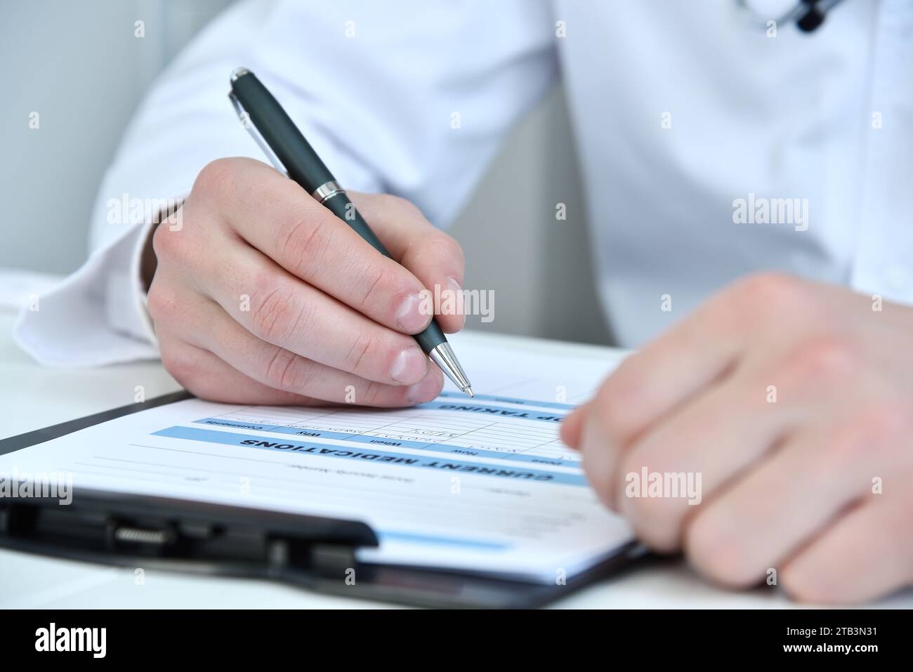 Doctor hands writing on clipboard in medical office patient notes on ...
