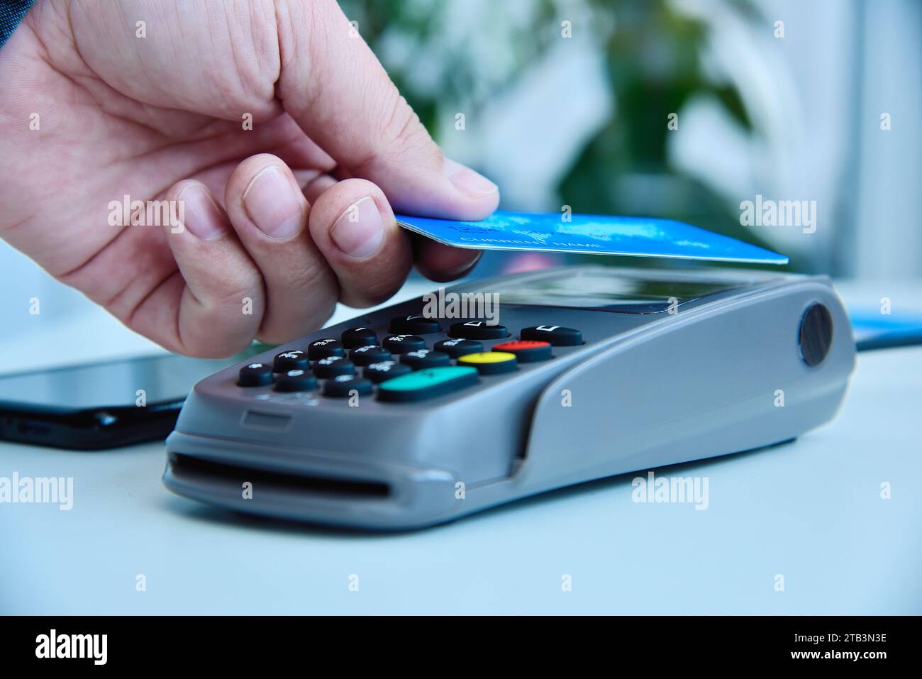 Hand customer holding blue credit card hear nfc pos terminal ...