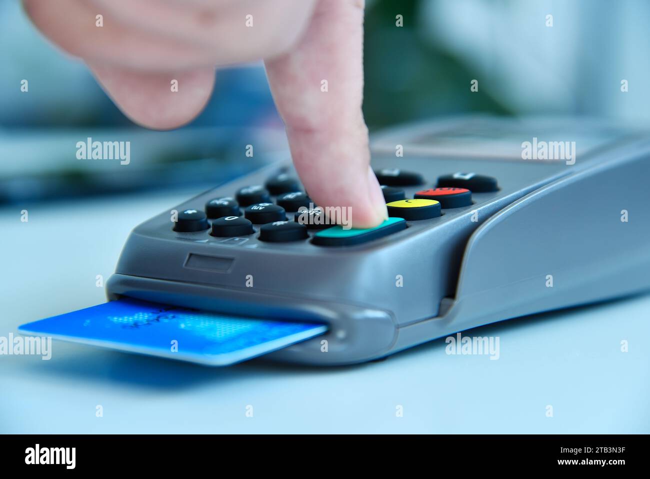 Hand dials pin code on pos terminal with blue credit card. Payment with ...