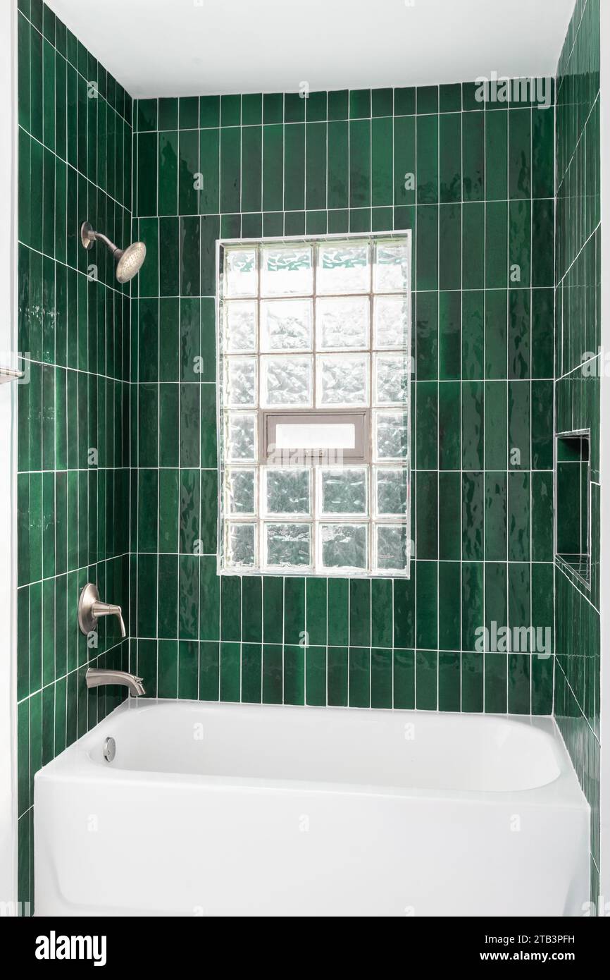 A bathroom shower detail with vibrant green vertical glass subway tiles ...