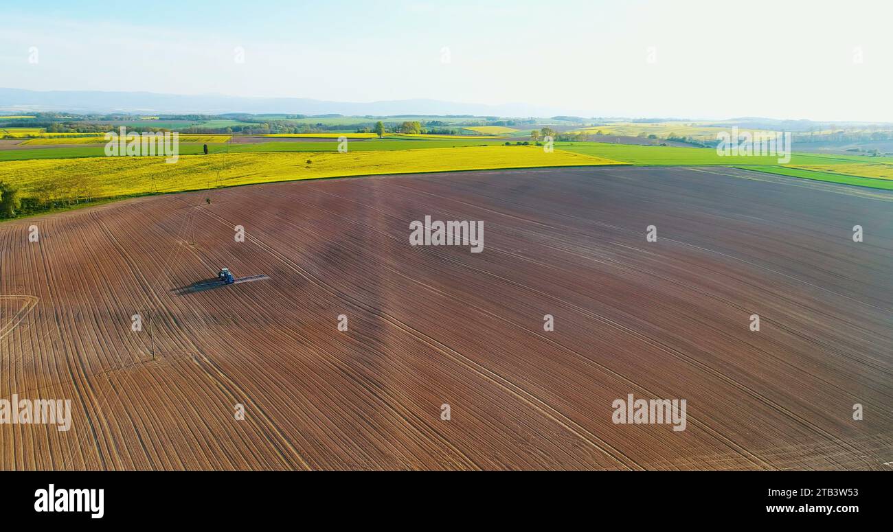 Farmer using tractor to spray field before planting Stock Photo - Alamy