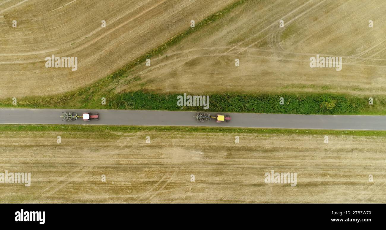 Aerial view of tractor passing road. Agricultural tractor workin on ...