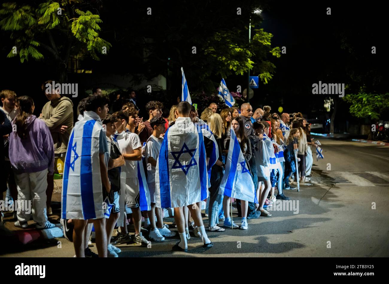 Herzlia, Israel. 04th Dec, 2023. Israelis gather in a street and wait ...