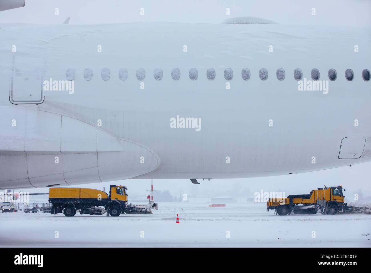 Winter frosty day at airport during heavy snowfall. Airplane covered ...