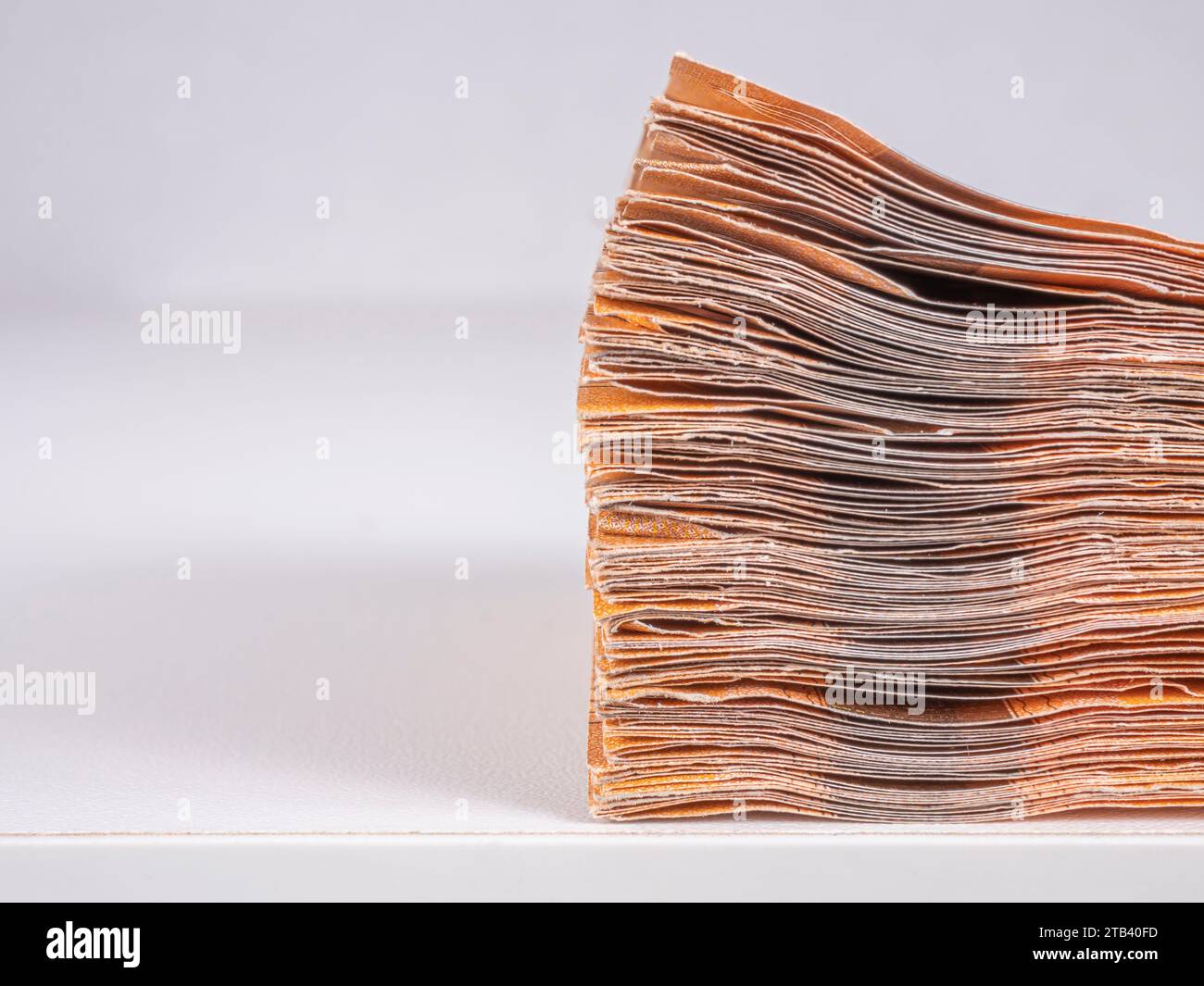 A stack of euro banknotes on the edge of a table, close-up, side view ...