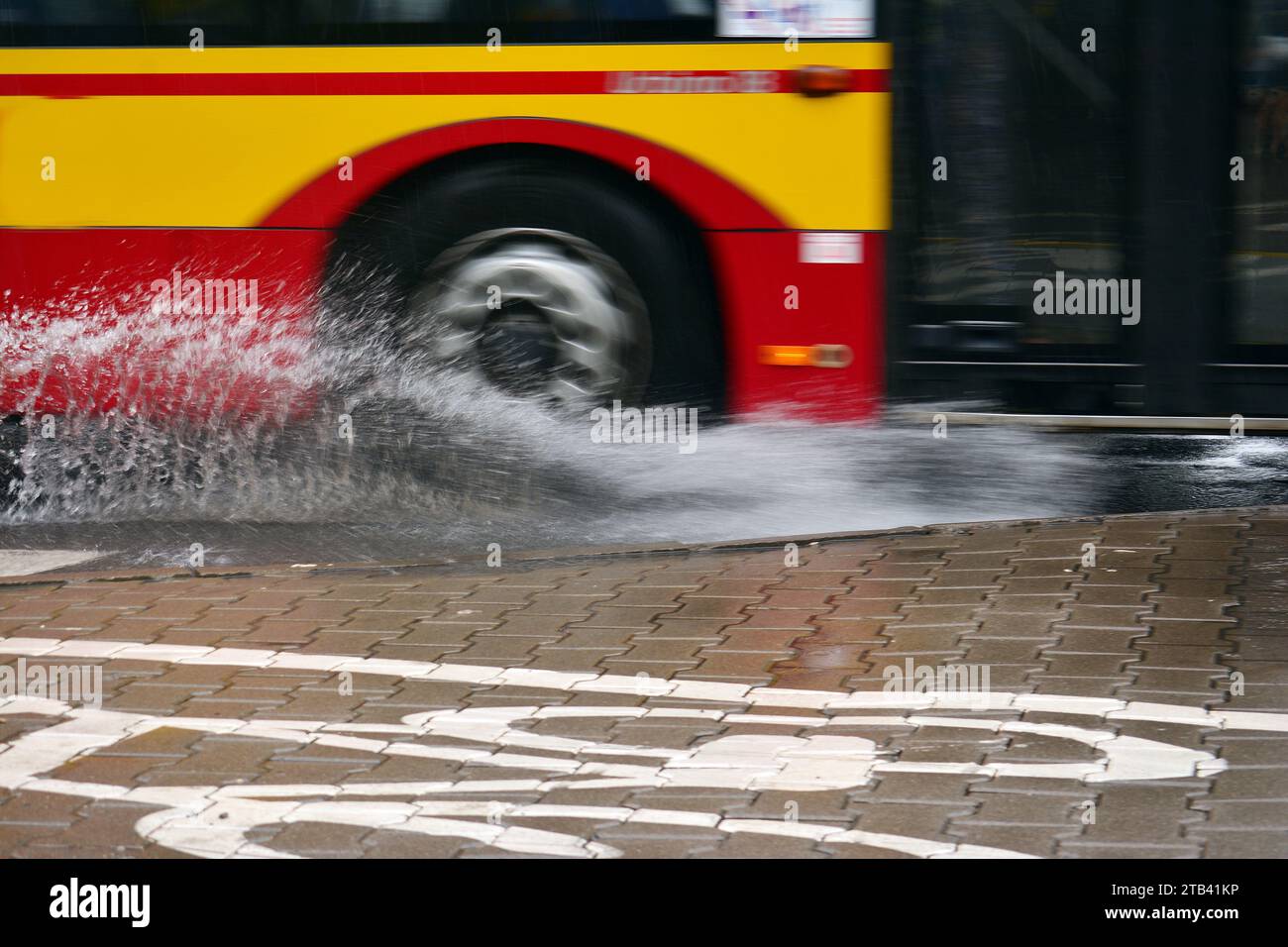 Splashes from under the wheels of the bus during heavy rain. Blurred ...