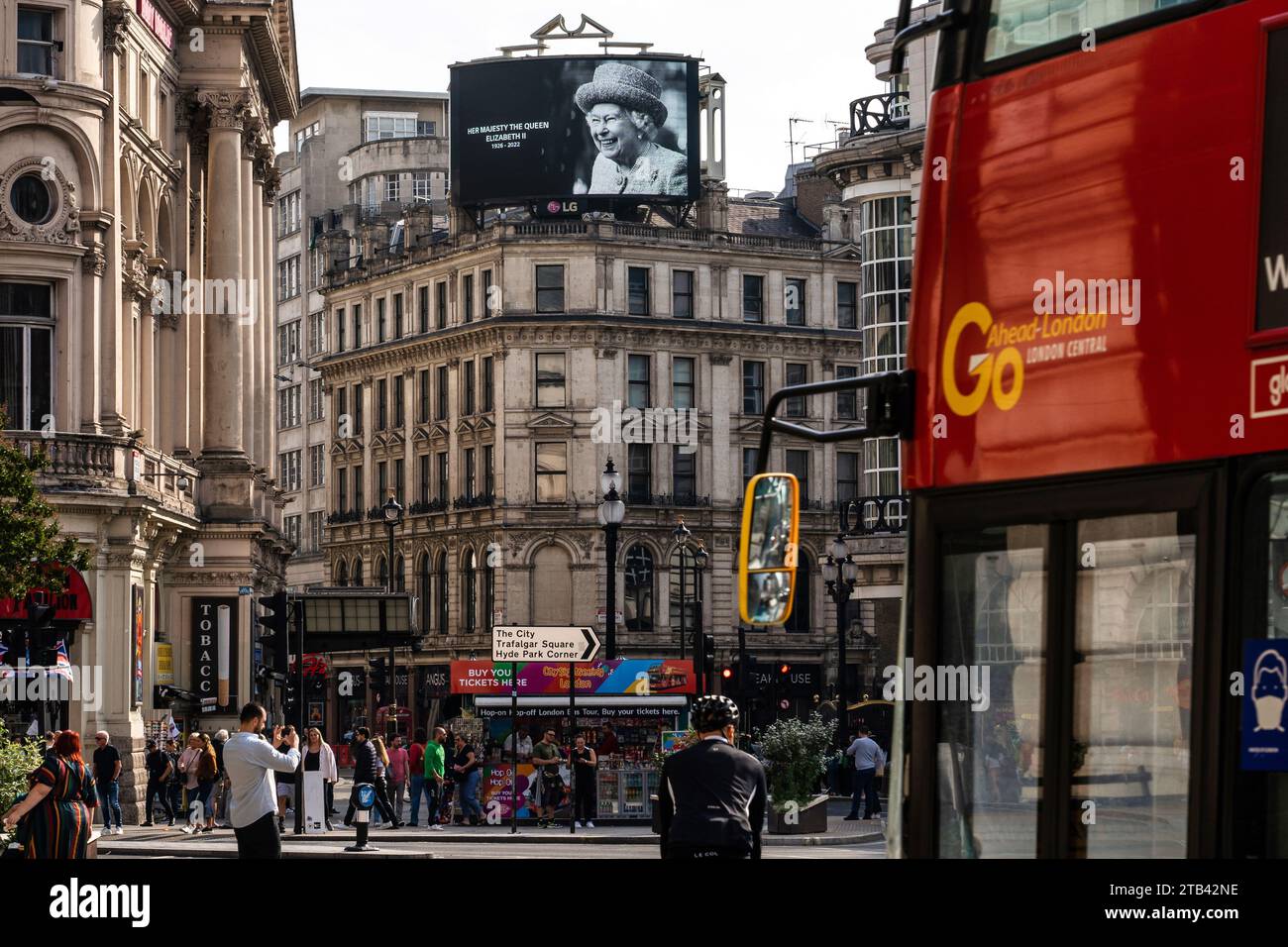 Red bus and traffic in London with the portrait of the late Queen ...