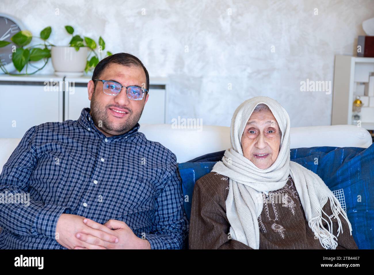 portrait for young male and his mother in living room with cheerful ...