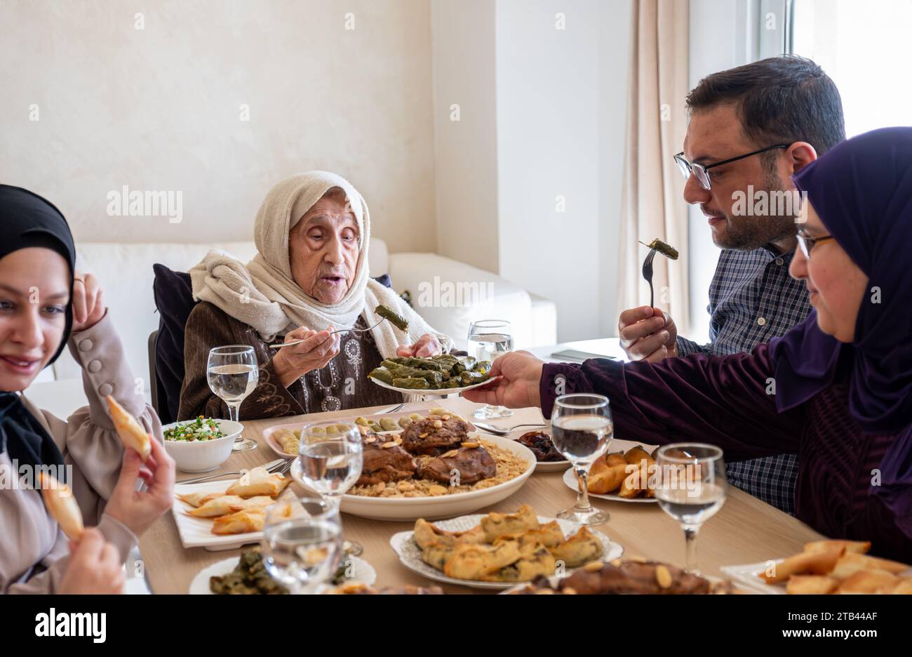 Arabian family having dinner together on wooden table with father ...