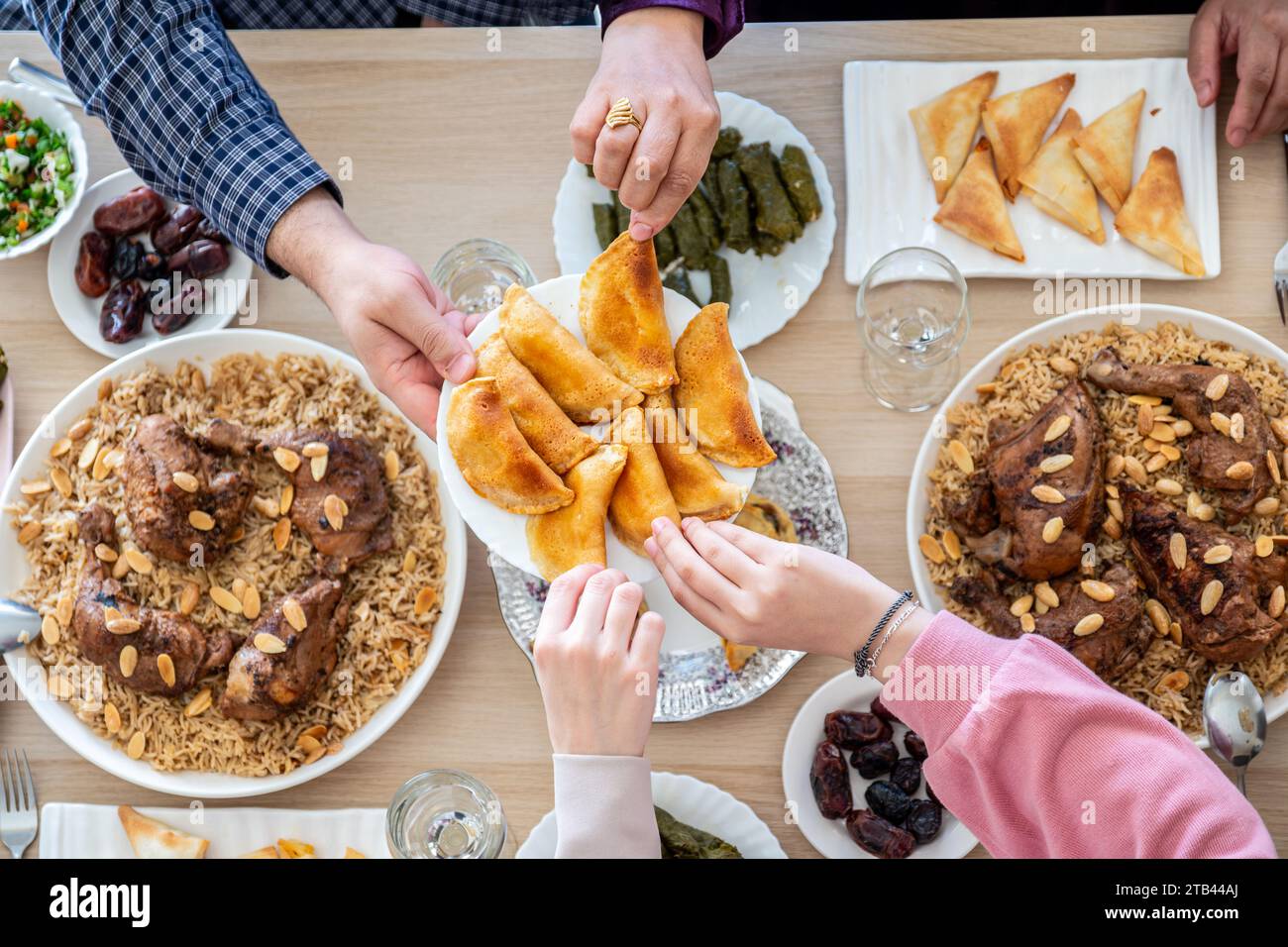Arabian family having dinner together on wooden table with father ...