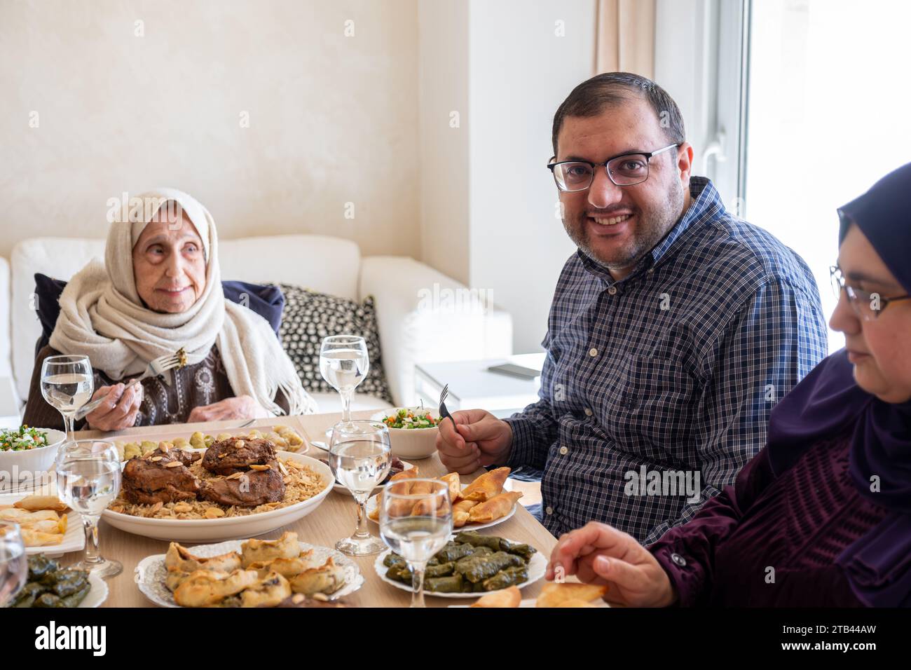 Arabian family having dinner together on wooden table with father ...