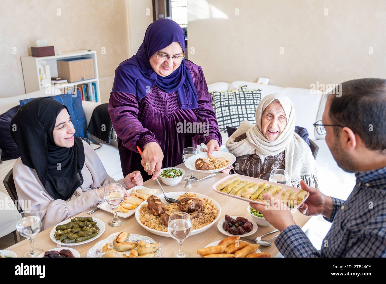 Arabian family having dinner together on wooden table with father ...