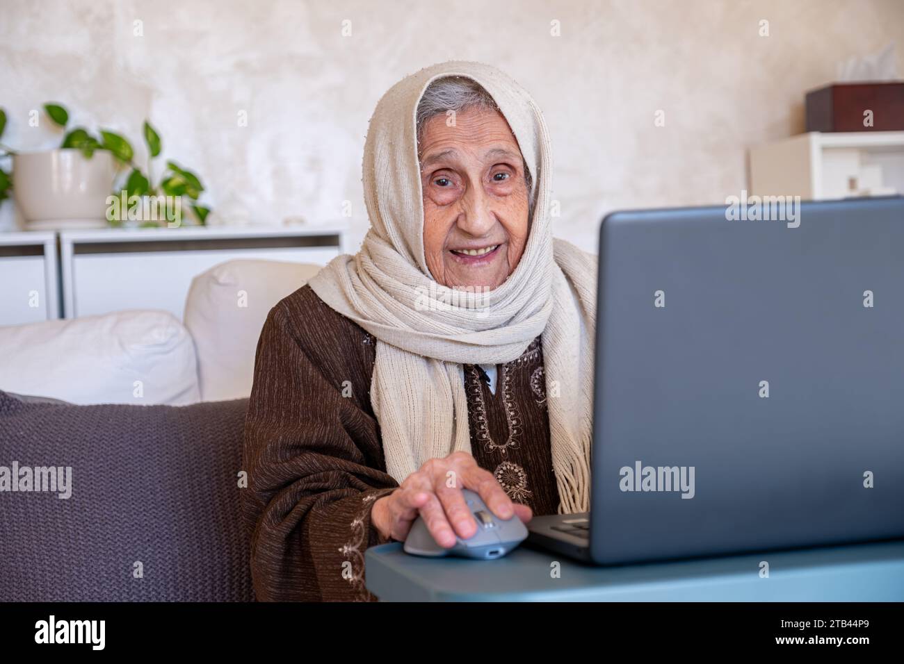 old lady using laptop in modern living room for online purposes Stock ...