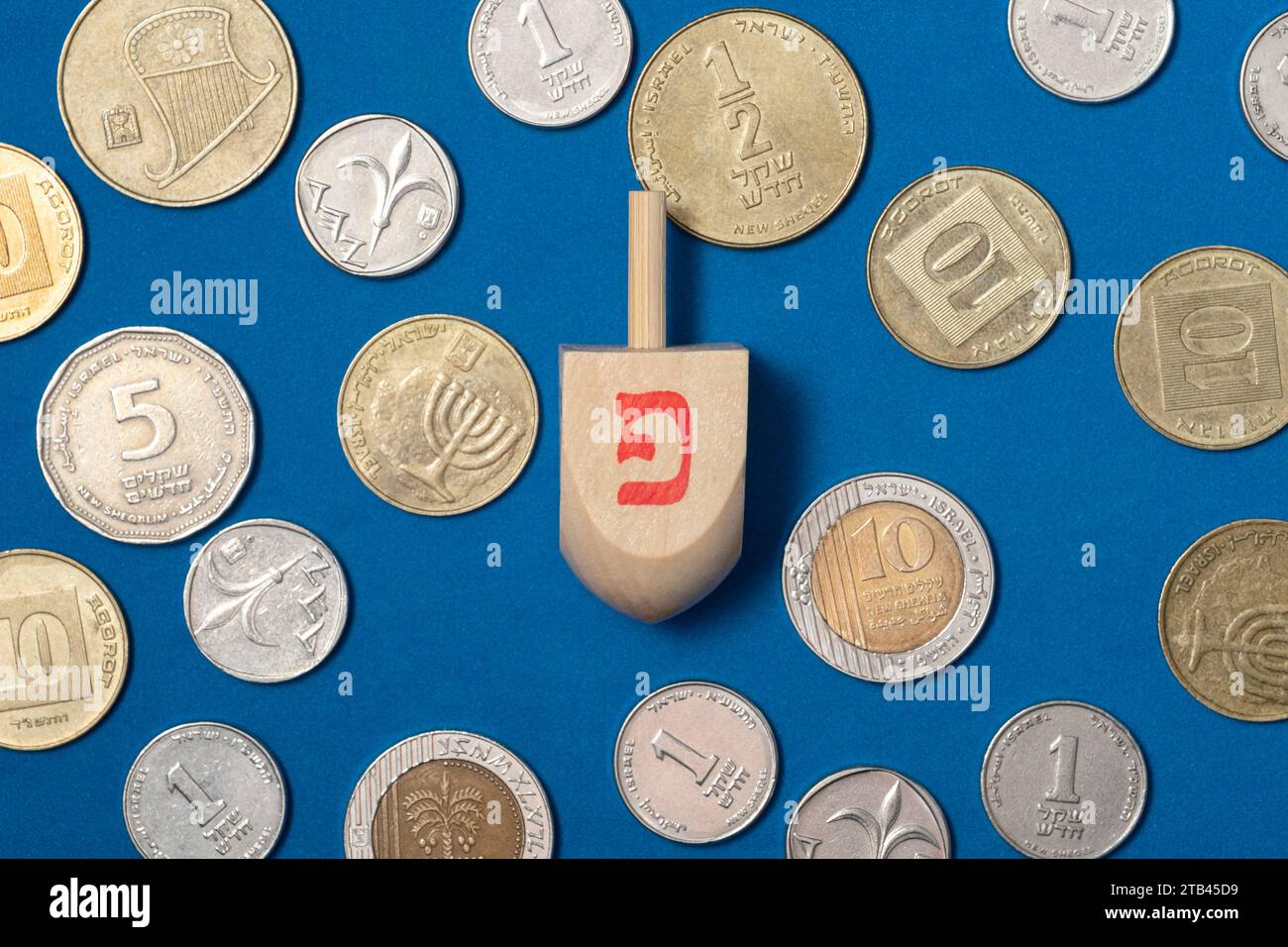 A Chanukah dreidel, a hand-painted natural wood spinning top, on a blue ...