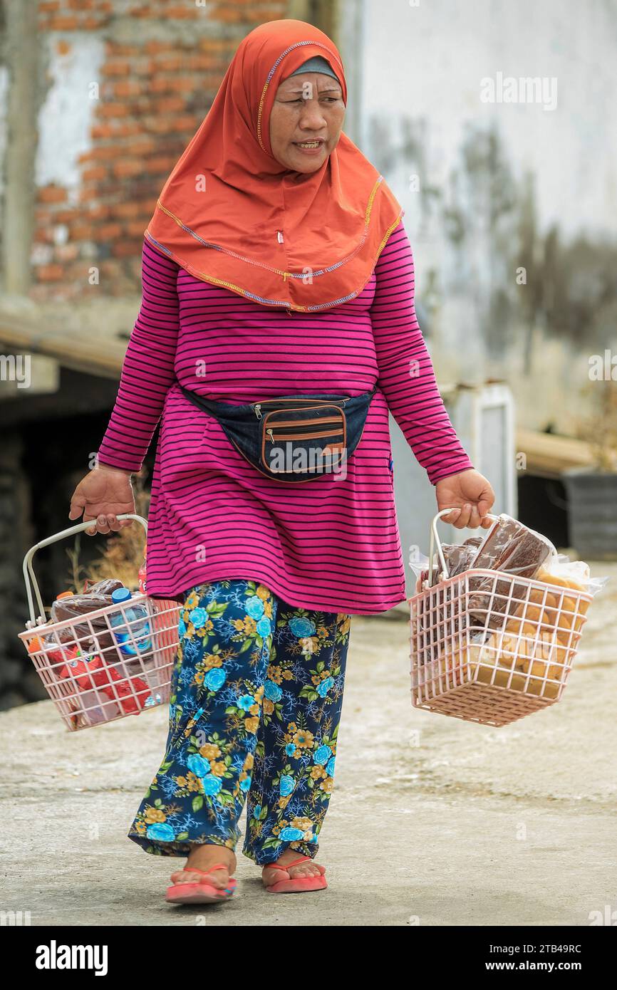 Woman in hijab selling snacks & drinks at the ferry wharf in the port ...