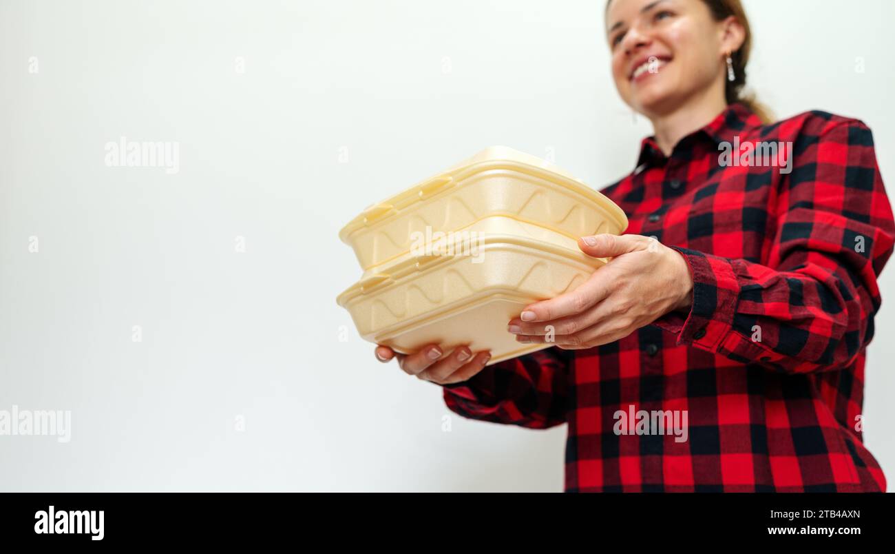 Female person delivering food. Woman holding lunch boxes in her hands ...