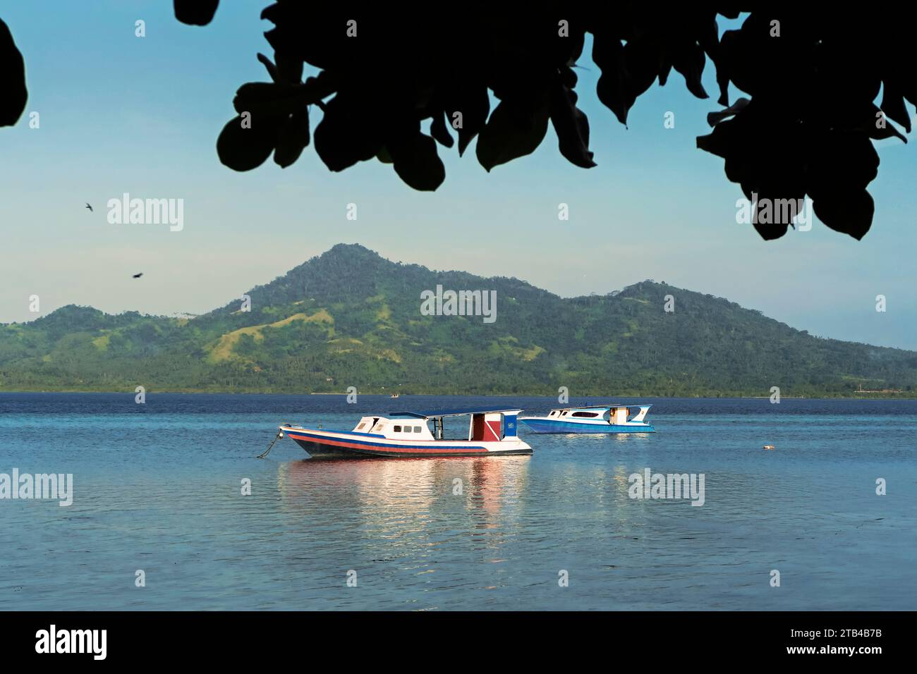 Ferry boat & view to the mainland & Gunung Tumpa at an eastern beach on ...