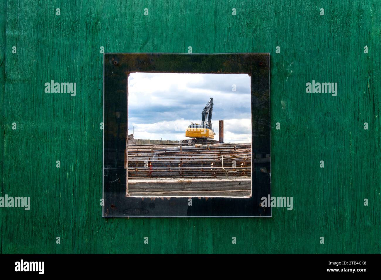 Viewing panel, porthole, or window in plywood wall around construction ...
