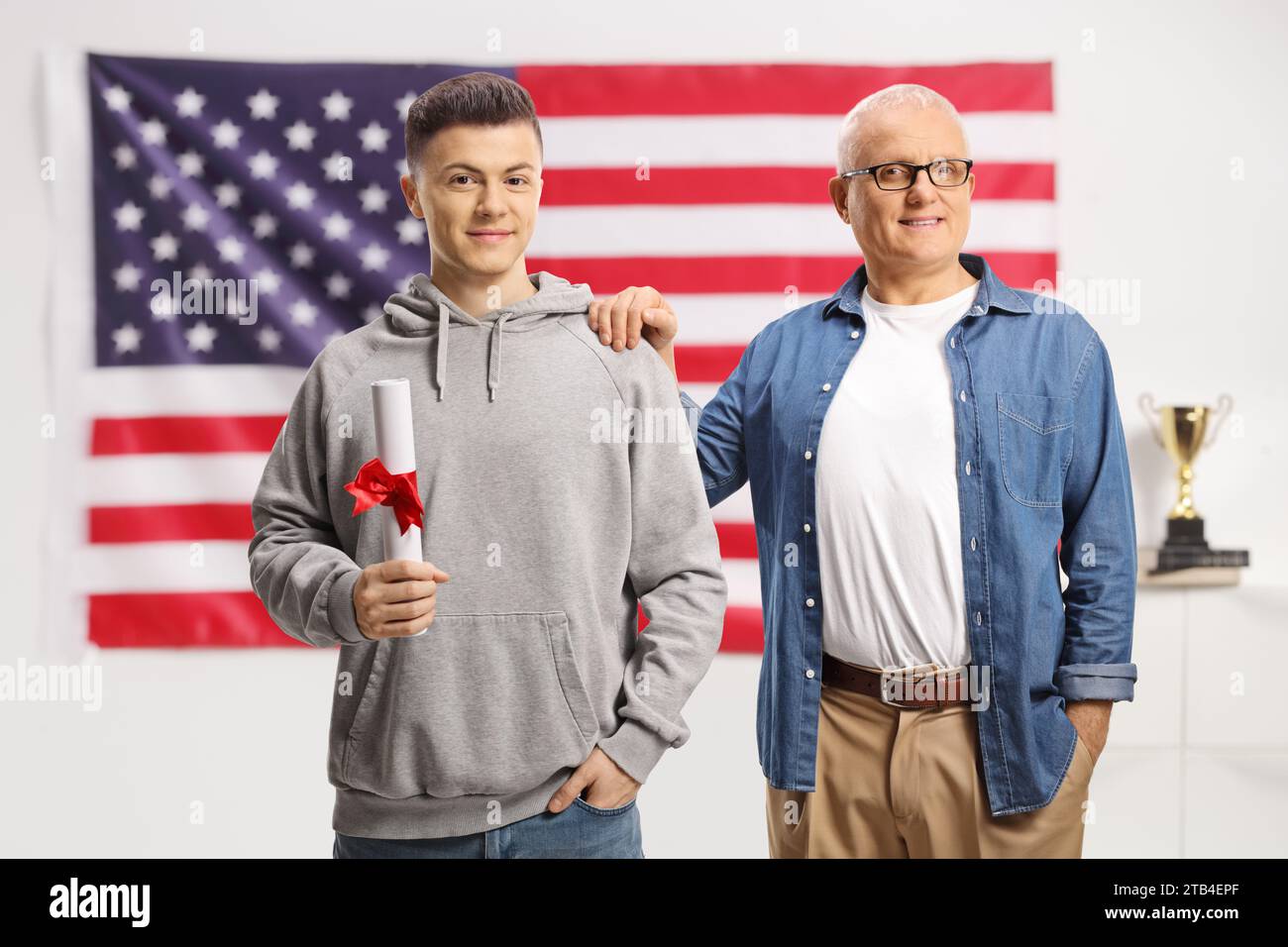 Father and son with a graduation certificate standing in front of an ...