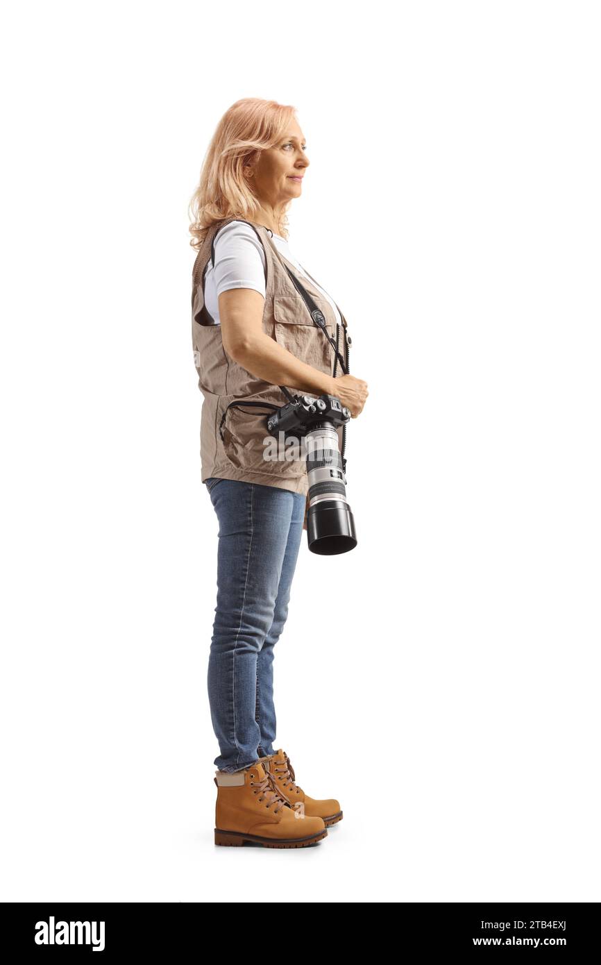 Full length profile show of a female photographer with a camera on ...