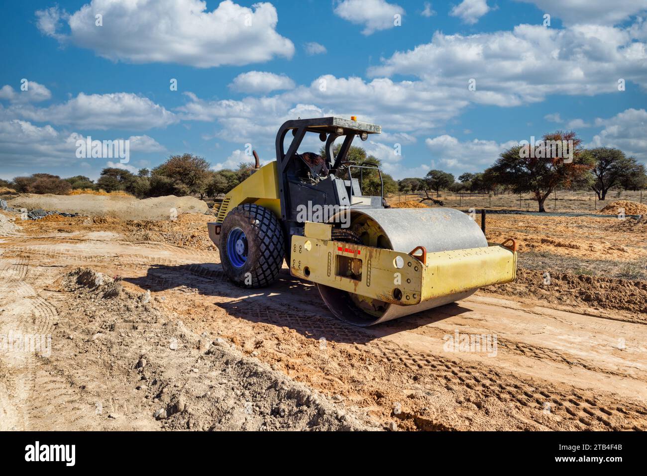 compactor heavy machinery paving a dirt road on a construction site ...