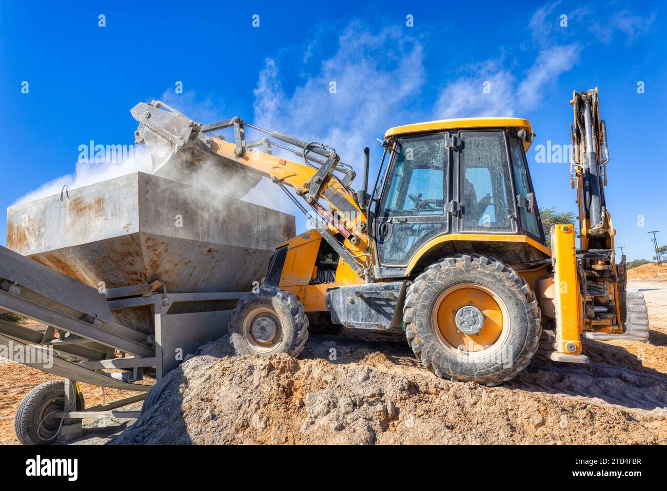 excavator loader backhoe loading a trailer with cement Stock Photo - Alamy